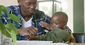 African man with his child coloring in book. spending quality time together bonding parenting