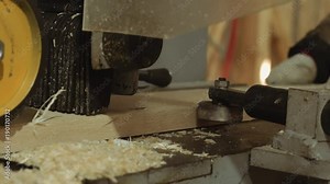 Rolling spiked wheels of plank refiner machine working on wood at lumber factory, close up