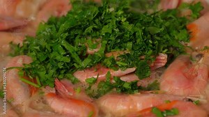 Tiger prawns roasting with herbs in a hot kitchen pan, the cook turns over with a wooden spatula. Cooking healthy seafood. Shrimps preparation. Cooking large shrimp in a shell in frying pan close-up