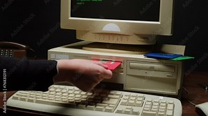 Using diskette FDD for old computer close-up. Hand inserting and ejecting Floppy Disk into vintage PC. Music recorder, playing retro computer games.