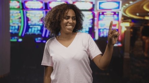 clip-3995679789-woman-smiling-points-index-finger-upward-row