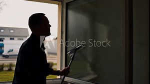 Window cleaning. Washing windows with a mop. A man carefully wipes the windows with a rag in the house. Cleanliness and order in the room. Housewife working moments
