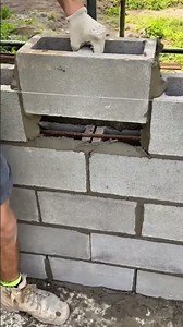 Masonry Work Laying Cinder Blocks with Mortar for a Retaining Wall