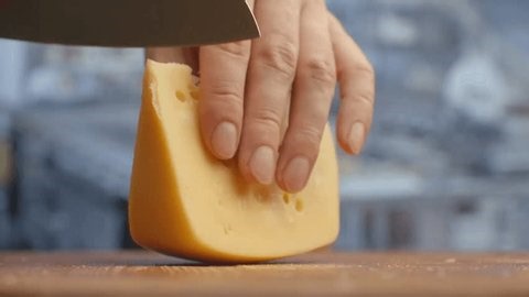 clip-3981102137-cook-grating-block-cheese-using-sharp-knife