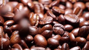 Coffee beans slow motion falling. High quality super slow motion coffee beans falling on a black table