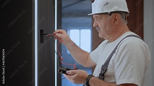 Man electrician checks the voltage in the network with a wire tester preparing to install a smart home