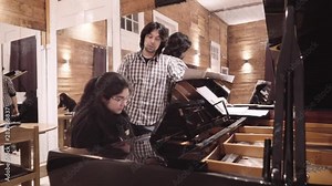 Young student taking piano lessons from a teacher. 4k