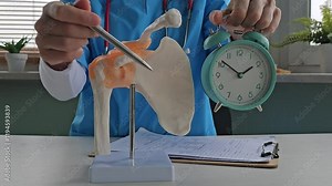 Doctor skeleton shoulder joint and muscles with alarm clock. Shoulder pain