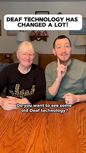 It’s amazing to see how much Deaf technology has evolved during my mom‘s lifetime! #deaftechnology #ad #signlanguage VD: Brad and his mom are sitting at a table in their family room. Brad is wearing a long sleeved green shirt. Mom is wearing a black shirt with ASL. I love you signs all over it that combines to make a giant ASL I love you sign. | Brad Klein - CODA Comedian
