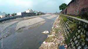Time Lapse shot of A polluted small river.water pollution, river pollution, dirty water. Environmental pollution. Plastic bottles,trash in river. Dirt floating in water.Water pollution India.River