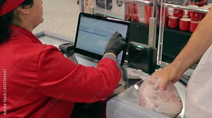 The cashier at the supermarket checkout scans the bar code of the product. The seller enters information about the purchase into the computer