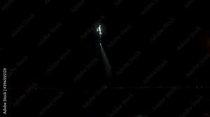 Flyboard, a new sport and show. A flyboarder in a backlit cast shows tricks in the night.