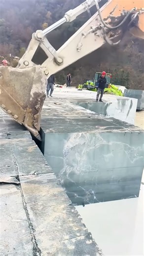 A quarrying process, where a large block of premium pine green stone is being extracted and polished to a reflective finish. #LuxuryStone #QuarryLife #NaturalElegance #StoneCrafting #PremiumMaterials | Metzgerei Ogunquit Studio