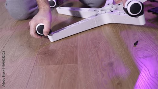 Installing caster wheels into plastic base of office chair during assembly