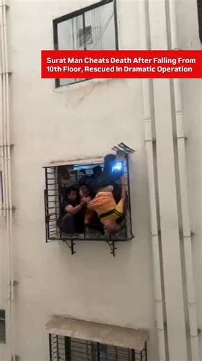 PUNE PULSE on Instagram: "Leg gets wedged in grille two floors below; hour-long rescue by fire teams saves 57-year-old A 57-year-old man in Surat narrowly escaped death after falling from the 10th floor of his apartment building early Thursday morning, only to have his fall arrested when his leg became stuck in a grille two floors below. The dramatic incident unfolded at the Times Galaxy building in Jahangirpura and was captured on video, showing the man hanging upside down as rescue teams worke