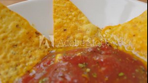 Triangular corn chips in hot sauce in a 360 degree rotating bowl