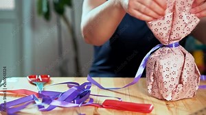 Close-up of a woman's hand packing a gift. Purple packing tape, camera slide right Stock Video