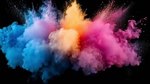 Abstract colorful explosion of ink in water with blue, yellow, and pink hues against black background.