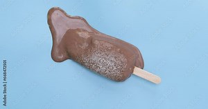 4K footage Time-lapse Top view Frozen popsicles melting with heat on blue background.