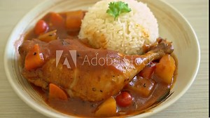 homemade chicken stew with tomatoes, onions, carrot and potatoes on plate with rice