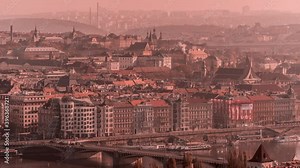View from the Petrin hill in Prague. The orange haze hanging in the air above the city. Traffic is low. There is no usual traffic jam on the crossroad in front of the Dancing house.