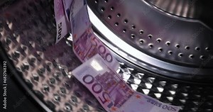 euro 500 paper money banknotes in the washing machine. dirty criminal money laundering and shadow economy concept