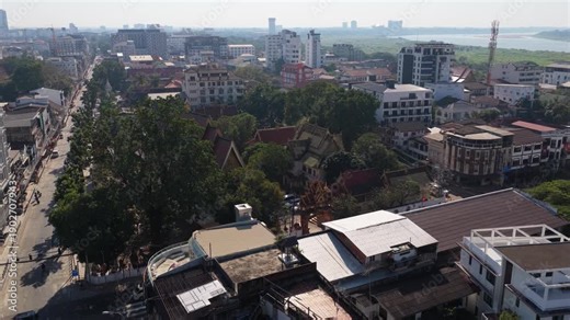 Urban landscape of Vientiane, Laos, featuring Mekong River bordering with Thailand and modern architecture under a clear sky during daytime