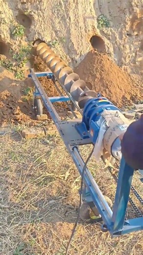 Drilling Horizontal Holes into a Dirt Wall with a Large Powered Screw Auger Machine