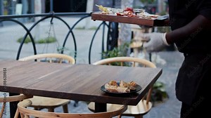 Food Service Worker Placing Bread and Charcuterie Plate on Table 4K Ultra HD Video