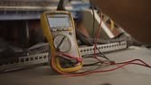 Close-up of a Fluke 117 multimeter in use, displaying voltage reading...