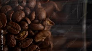 Coffee beans fall in slow motion and cover the entire screen. Roasted aromatic brown coffee beans. Dark roast Arabica coffee beans falling. Roasted aromatic coffee.