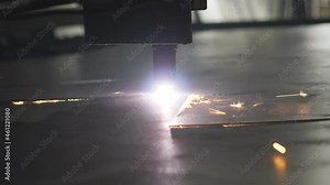 Plasma cutting of metal plate with a cnc. Manufacturing a workpiece from a sheet of steel. Laser cutter in work. Industrial metalworking production. Making details at workshop. Close up Slow motion