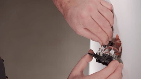 clip-3989368647-electrician-hands-installing-electrical-light-switch ...