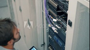 Server IT Engineer In Data Center Server Room.Network Engineer Working Laptop Computer.Server Rack Room Works.Programmer Checks A work Of Server At A Data Center.