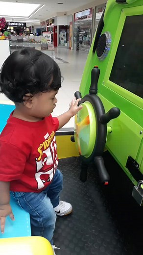 Toddler Enjoys Colorful Coin-Operated Ship Ride