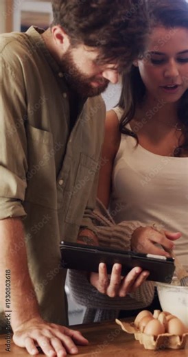 Couple, talk and baking in kitchen with tablet, online recipe and instructions for meal preparation. Married people, website and discussion in home with tech, method and ingredients for breakfast.