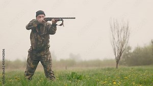 Morning foggy hunting on the background of autumn field. The hunter, armed with a rifle and a knife, saw the prey. Next to him sits a hunting dog, the hunter gives him the command to hunt Stock Video