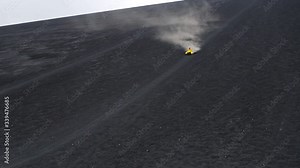 A single person does volcano boarding on Cerro Negro volcano in Nicaragua. Filmed from the bottom of the slope as the rider slides towards the camera