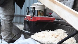Jointer, carpentry tool, side view. Workflow, a white man picks up a customized wooden board, outside the house. Concept: carpentry, home repairs, working tools, wood products.