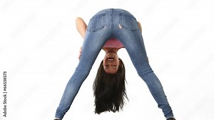 Back view of young woman in tight jeans bending over and smiling