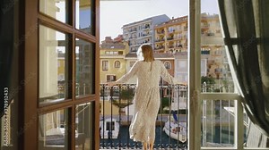 Beautiful back view of young woman opens doors and windows to balcony looking enjoying light and city view in the morning silhouette nature old city slow motion