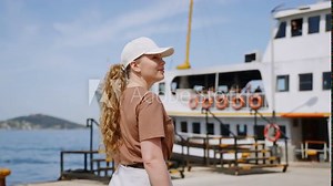 Woman boards ferry boat, long hair, casual wear, sunny dockside scene. Female passenger awaits departure on pier, sunny seaside setting with watercraft in background.