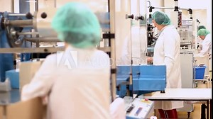 Pharmaceutical Industry Production Line Workers Working on Pill Packaging Line. Tablet , Pill and Capsule Packaging Line in Pharmaceutical Factory. Four Pharmaceutical Production Technicians at Work.