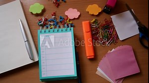 Colored stationery - glider, marker, buttons, paper clips, scissors on a wooden background. Planning your day, accounting and studying at school