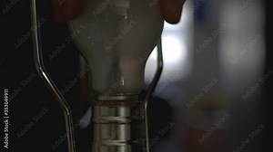 Installing A Light Bulb Into A Socket And Lighting It - closeup shot