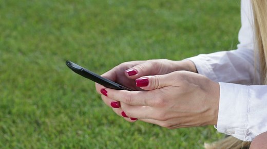 Woman scrolling through her phone - Free Stock Video