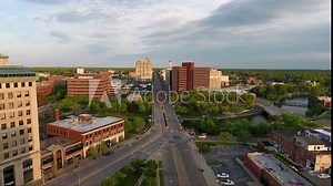 An drone flies above downtown Flint, Michigan revealing the University of Michigan building, Saginaw Street, the Flint River, the City Center and other prominent buildings.
