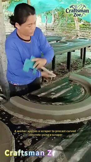A worker applies a scraper to precast curved concrete using a scraper