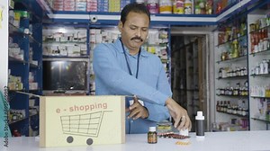 Pharmacist packing medicines inside the box for online purchases at retail medical store - concept of e-commerce, online business and home delivery service