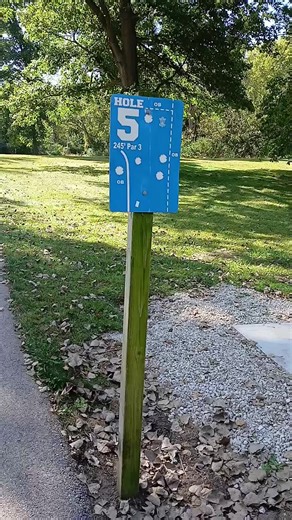 Disc golf hole number 5 sign on a wooden post at a park in Illinois in Fall Autumn. #illinois #discgolfholesign #sign #park #autumn